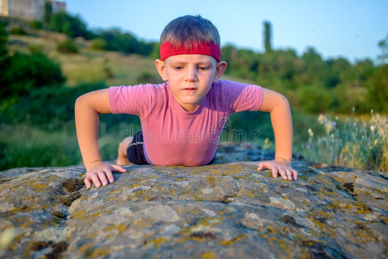 Young Boy Doing Push-ups on a Rock Stock Image - Image of child, summer ...
