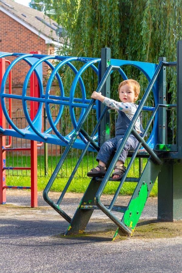 Young Boy in Dungarees Alone on a Playground Stock Photo - Image of ...