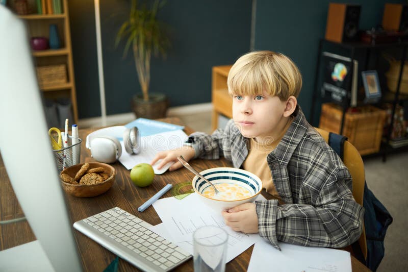 Young Boy Eating Breakfast Using Computer Stock Photos - Free & Royalty ...