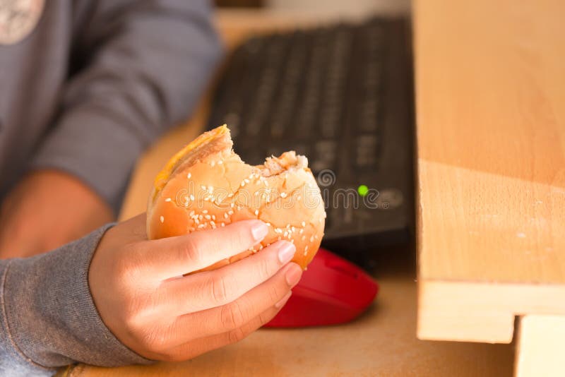 Young Boy Eating Burger and Using Computer Stock Image - Image of ...
