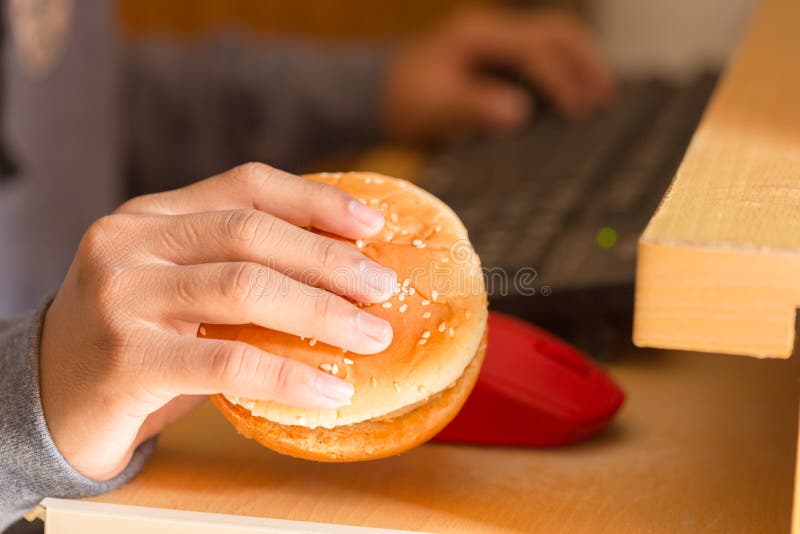 Young Boy Eating Burger and Using Computer Stock Image - Image of ...