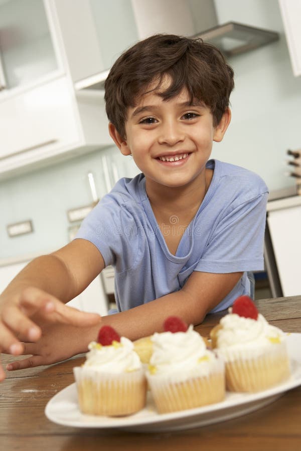Young Boy Eating Cakes in Kitchen Stock Photo - Image of happy, inside ...