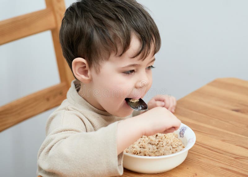 Young Boy Eating Oatmeal for Breakfast Stock Photo - Image of people ...