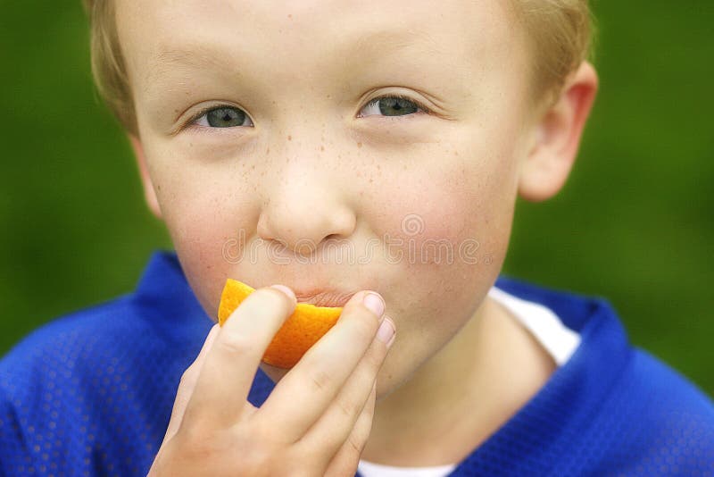 Young Boy Eating an Orange Outside Stock Photo - Image of camera ...