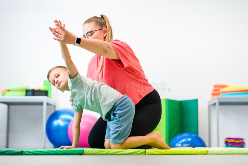 Young Boy Exercising with Female Physical Therapist during Therapy ...