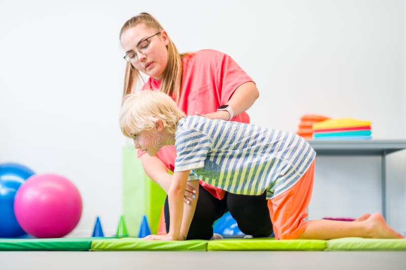 Young Boy Exercising with Female Physical Therapist during Therapy ...