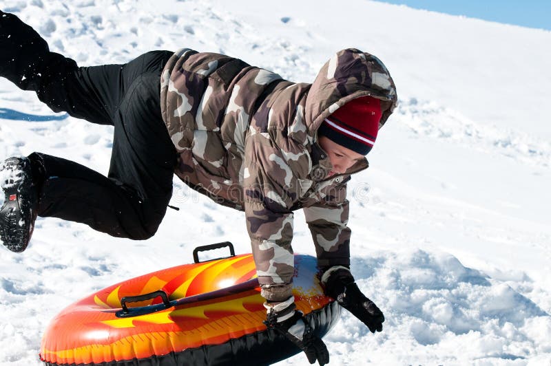 Young Boy Flying Off Snow Tube Stock Image - Image of happiness, play ...