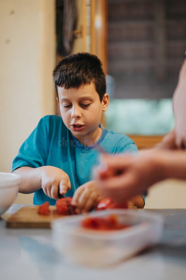 Young Boy Learning To Cook Slicing Vegetables in Kitchen Stock Image ...