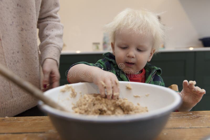 A Young Boy Gets His Hands into the Cake Mixture Whilst Helping To Bake ...