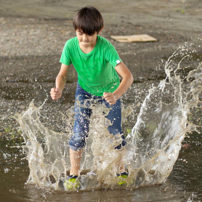 A Young Boy Jumping into a Puddle Stock Photo - Image of adventure ...