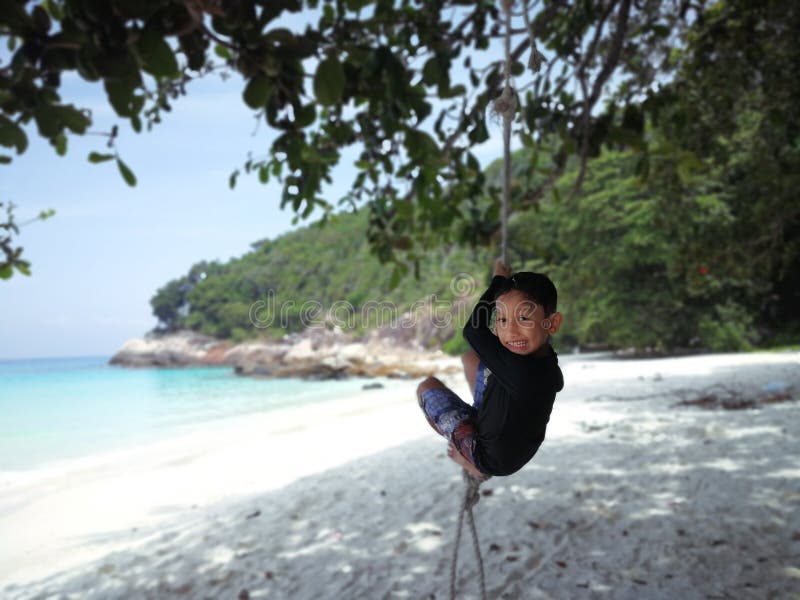 A Young Boy is Hanging at the Rope by the Beach. Stock Photo - Image of ...