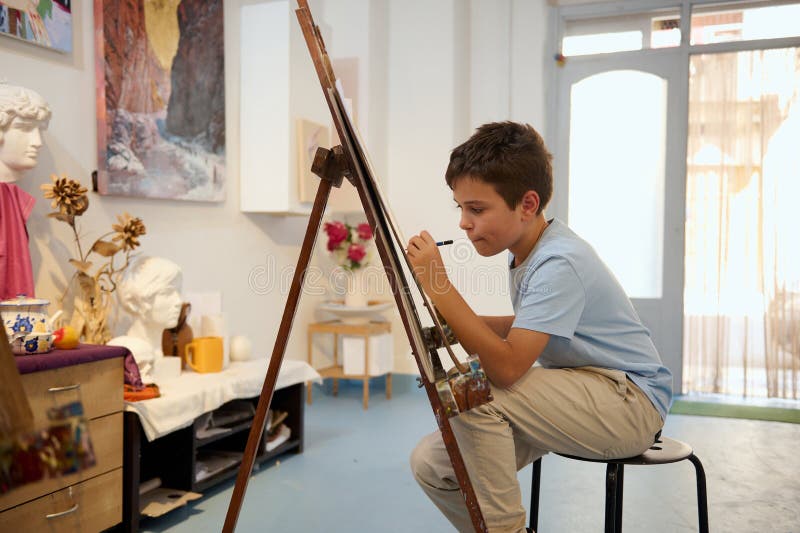 Young Boy Having an Art Class, Drawing and Painting on an Easel with ...