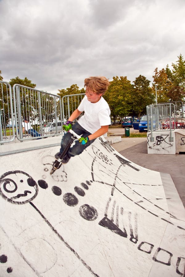 Young Boy Jumps with Scooter Over a Ramp at the Sk Stock Image - Image ...