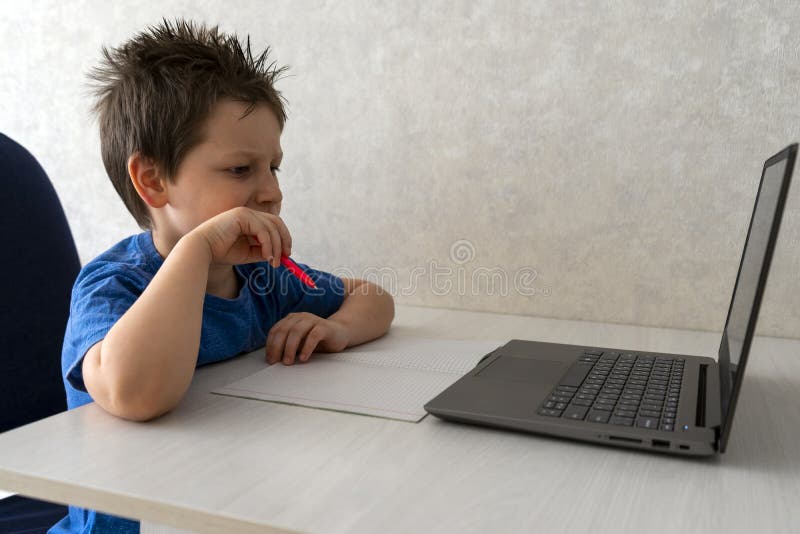 A Young Boy is Learning Remotely on a Laptop at a Desk Stock Image ...