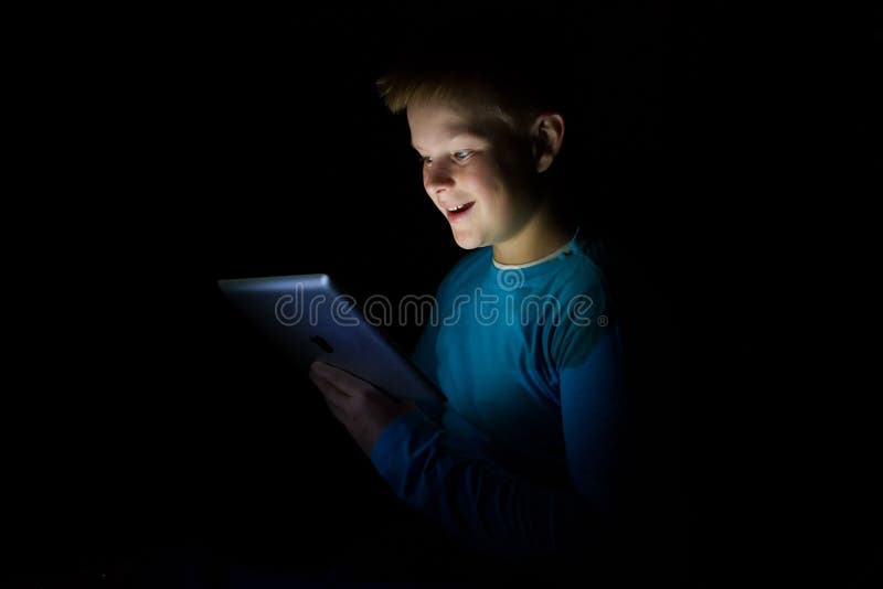 Young Boy with Light Hair Play with a Tablet in Dark Stock Image ...