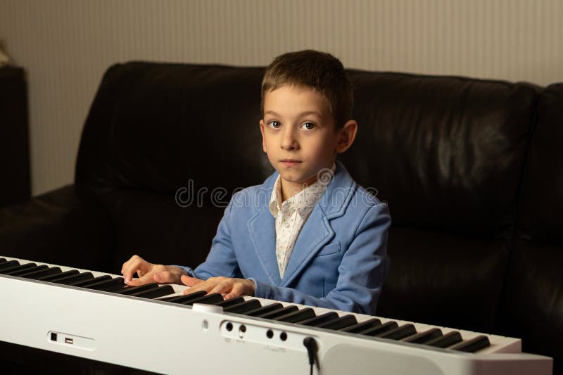 Young Boy Looking Up while Playing Piano Stock Image - Image of ...