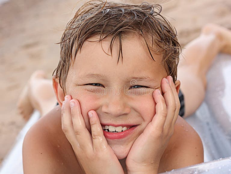 Young Boy Lying on the Beach Stock Photo - Image of happy, portrait ...