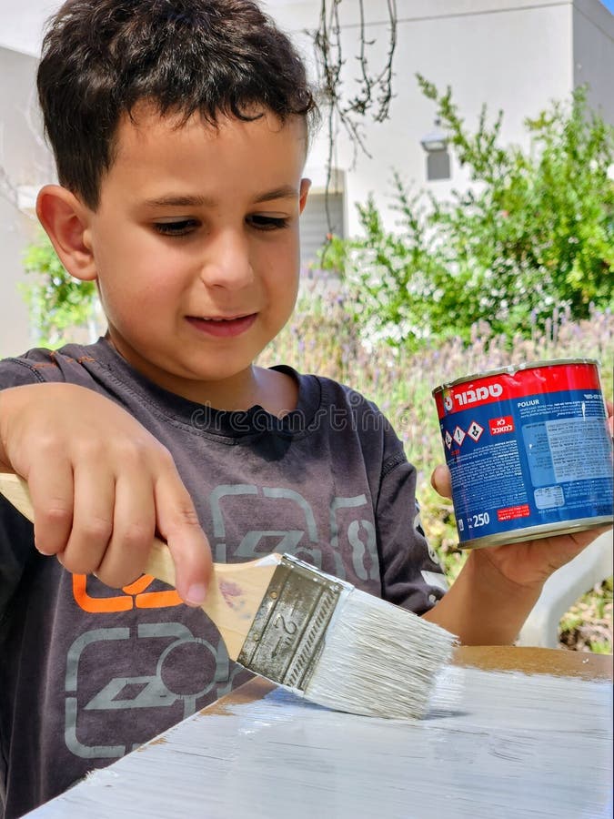 Young Boy Painting a Wall with a Paintbrush in His Hand. Stock Photo ...
