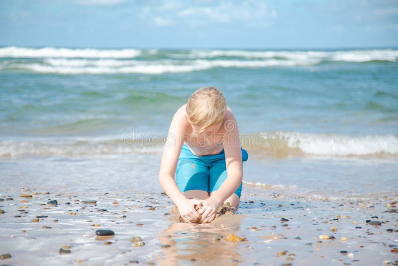 Young Boy Playing on the Beach Digging in the Sand on a Summer Day ...