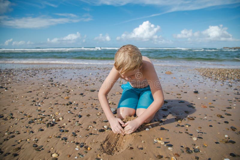 Young Boy Playing on the Beach Digging in the Sand Stock Photo - Image ...