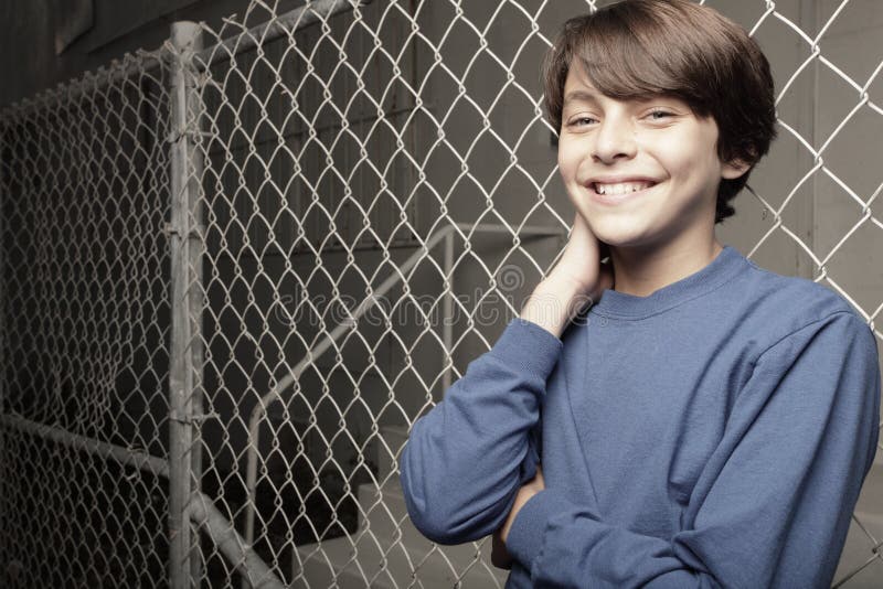 Young Boy Posing on a Chain-link Fence Stock Photo - Image of teenager ...