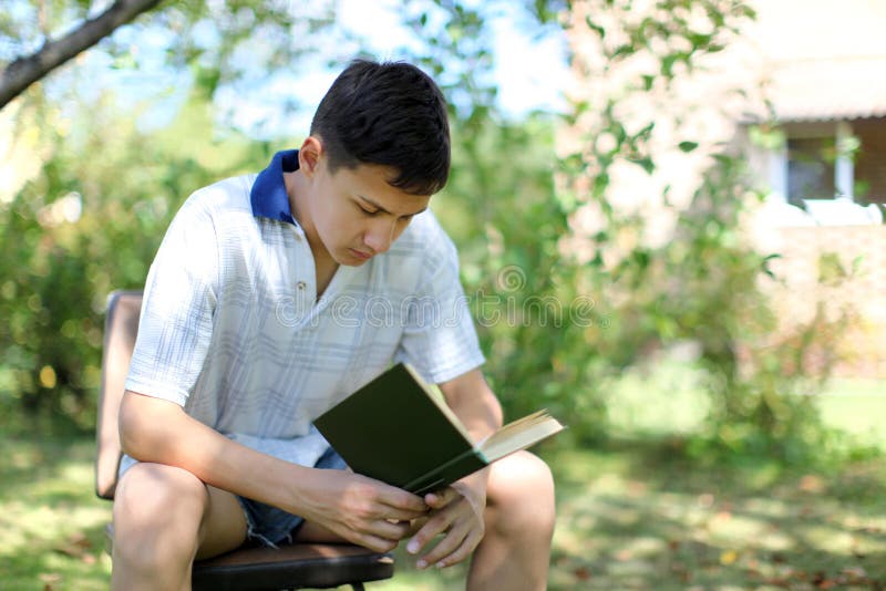 Young Boy Reading Book Outdoors Stock Image - Image of outside ...