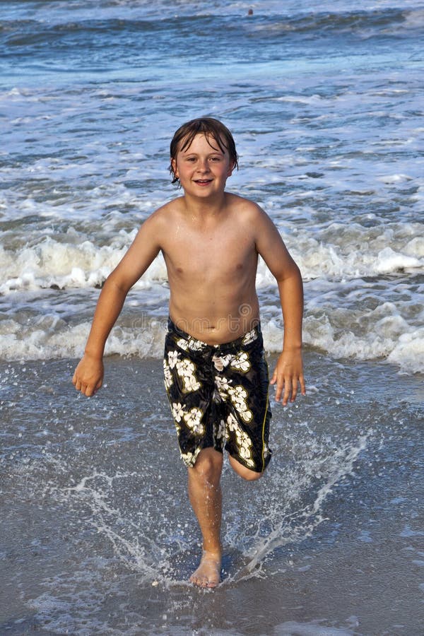Young Boy Running through the Water at the Beach Stock Image - Image of ...