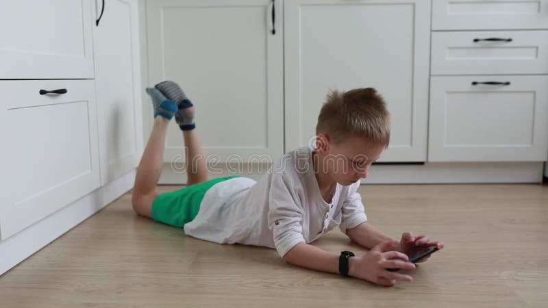 Young Boy Laying on Floor Using Cell Phone Stock Video - Video of ...