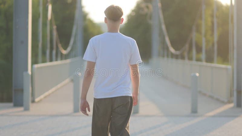 Teen Boy Walking Alone in Silence on an Empty Pedestrian Bridge Stock ...
