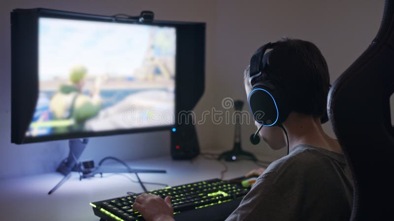 Young Boy Sitting in Front of a Computer, Playing a Game Wearing a ...