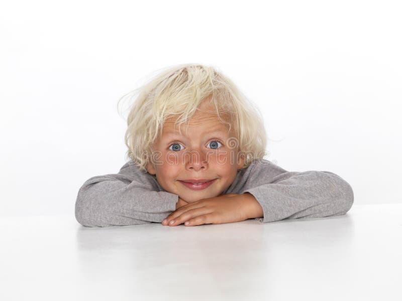 Young Boy Sitting at a Table Stock Photo - Image of blue, child: 10573678