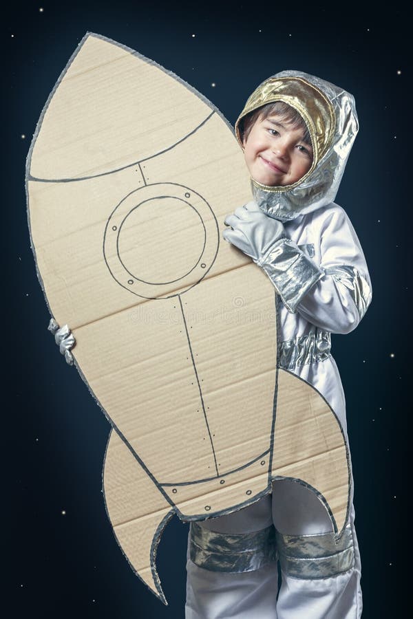 A Young Boy in a Space Suit Holding a Cardboard Rocket Stock Image ...