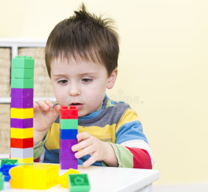 Young Boy Stacks Connecting Blocks Stock Photo - Image of concentrating ...