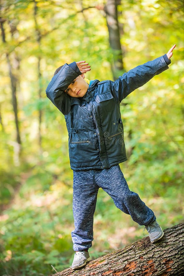 Young Boy Standing on Fallen Down Tree Trunk and Catching Balance Stock ...