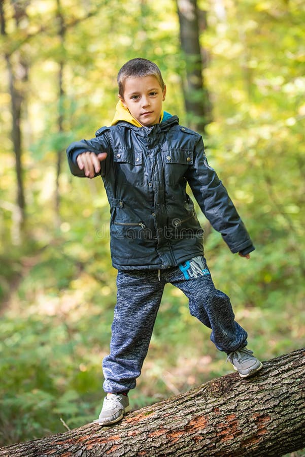 Young Boy Standing on Fallen Down Tree Trunk and Catching Balance Stock ...