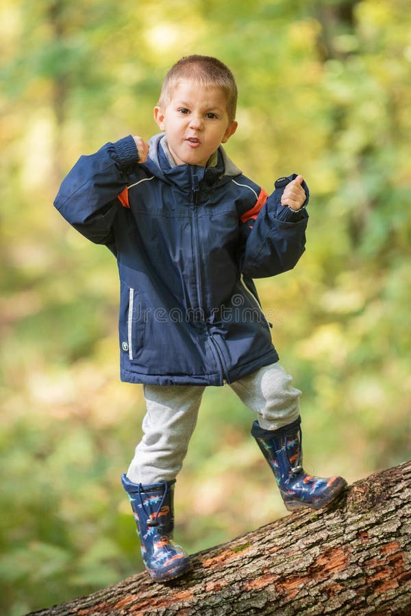 Young Boy Standing on Fallen Down Tree Trunk and Catching Balance Stock ...