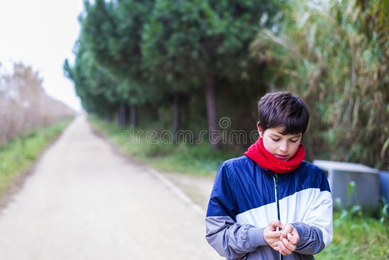 Young Boy Standing on a Pathway while Looking Down Stock Photo - Image ...