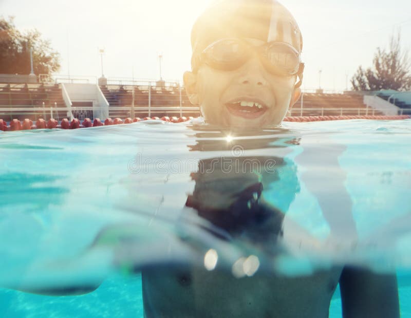 Young Boy Swimming with Half of Face Under Water Backlit Stock Photo ...
