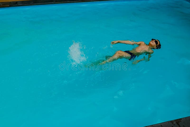 Young Boy is Swimming on His Back in the Swimming Pool. Sport Vacation ...