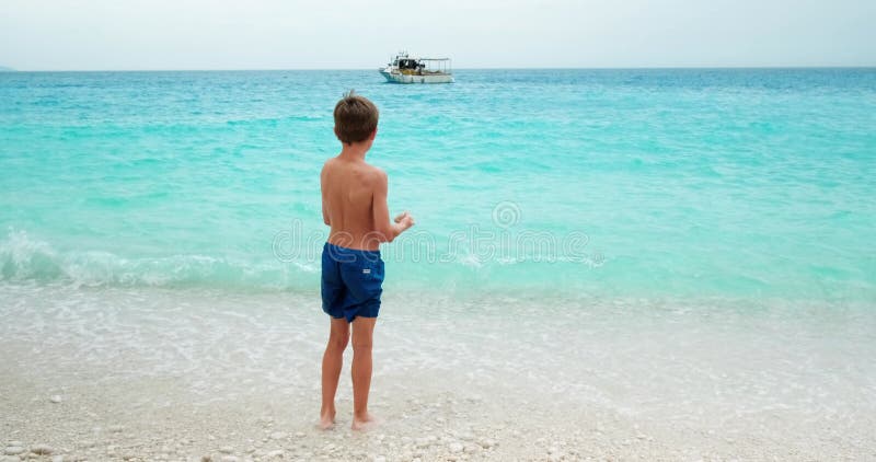 Young Boy Throwing Rocks in the Sea at the Beach. Stock Video - Video ...