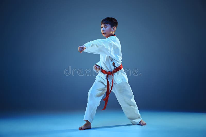 Young Boy Training Karate on Blue Background Stock Image - Image of ...