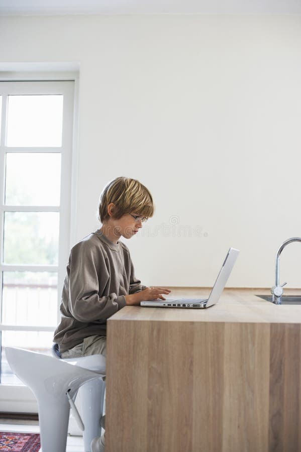 Young Boy Using Laptop at Kitchen Table Stock Photo - Image of computer ...