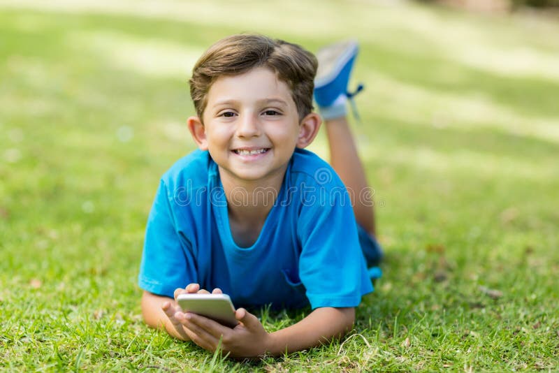 Young Boy Using Mobile Phone Stock Photo - Image of cheerful, grassland ...