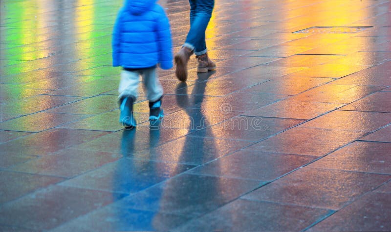 Young Boy Walking on Wet Pavement Stock Image - Image of blurred ...