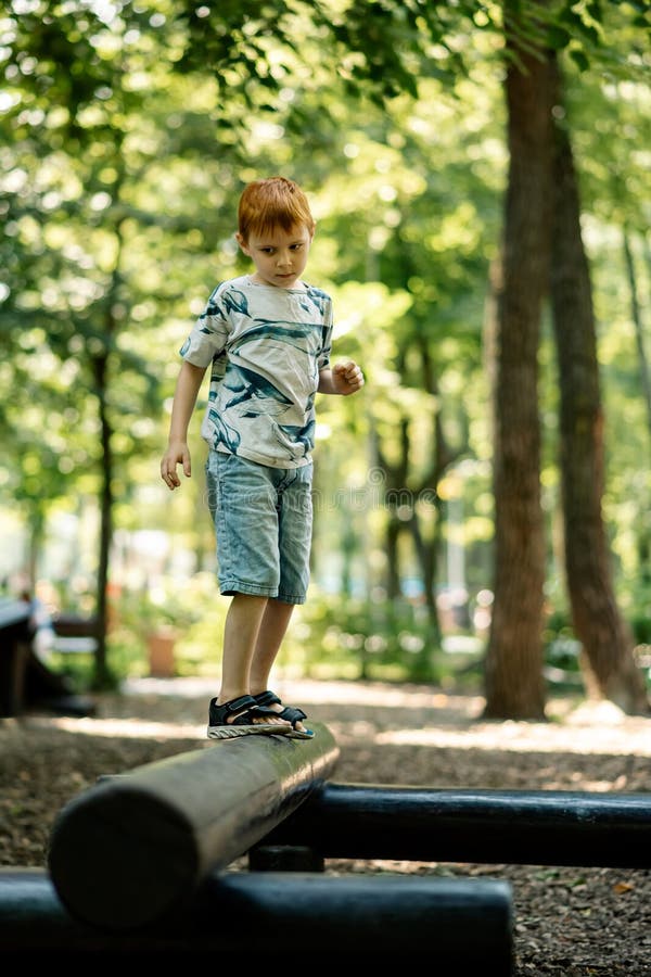A Young Boy Walks on a Log at the Playground. Active Summer Vacation ...