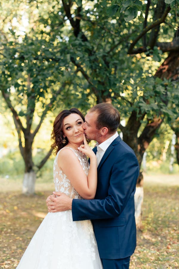 Young Bride and Groom Walking in a Summer Park with Green Trees Stock ...