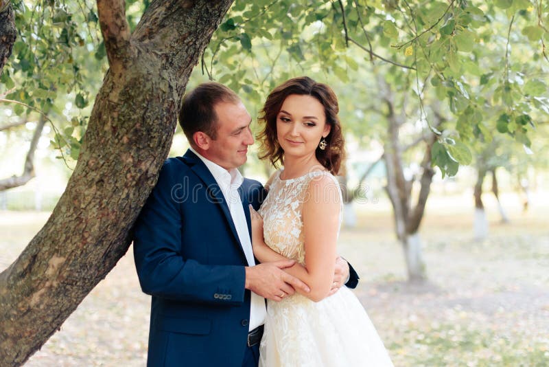 Young Bride and Groom Walking in a Summer Park with Green Trees Stock ...