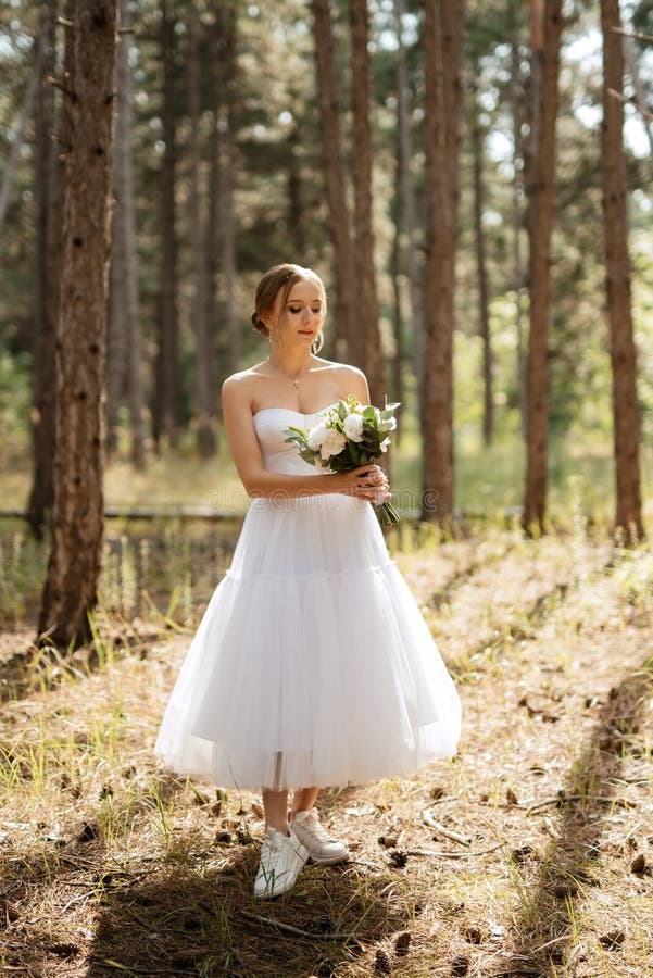 Young Bride in a White Short Dress in a Spring Pine Forest Stock Photo ...