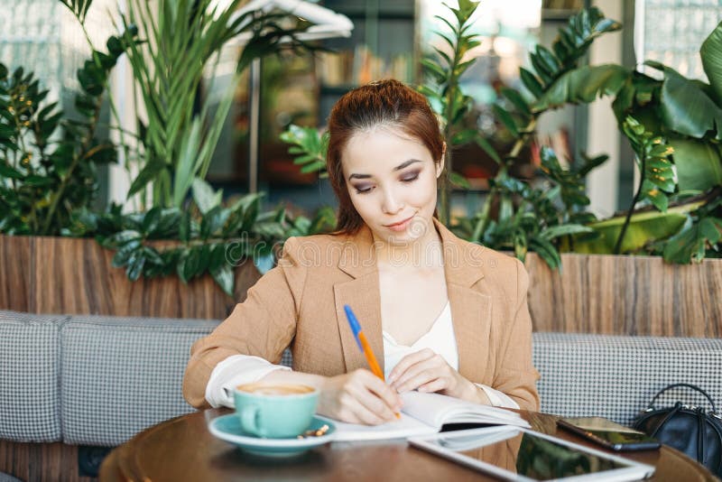 Young Brunette Girl Student Doing Homework in Notebook with Coffee ...
