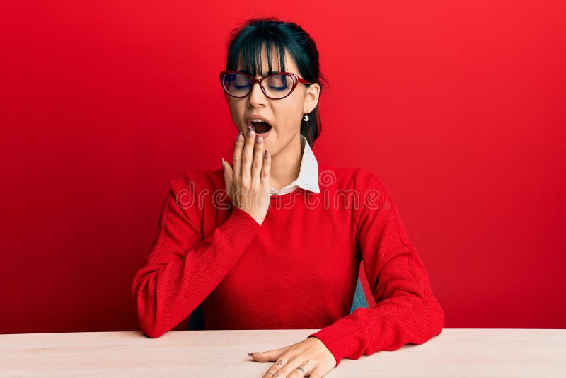 Young Brunette Woman with Bangs Wearing Glasses Sitting on the Table ... Young Brunette Woman with Bangs Wearing Glasses Sitting on the Table ...